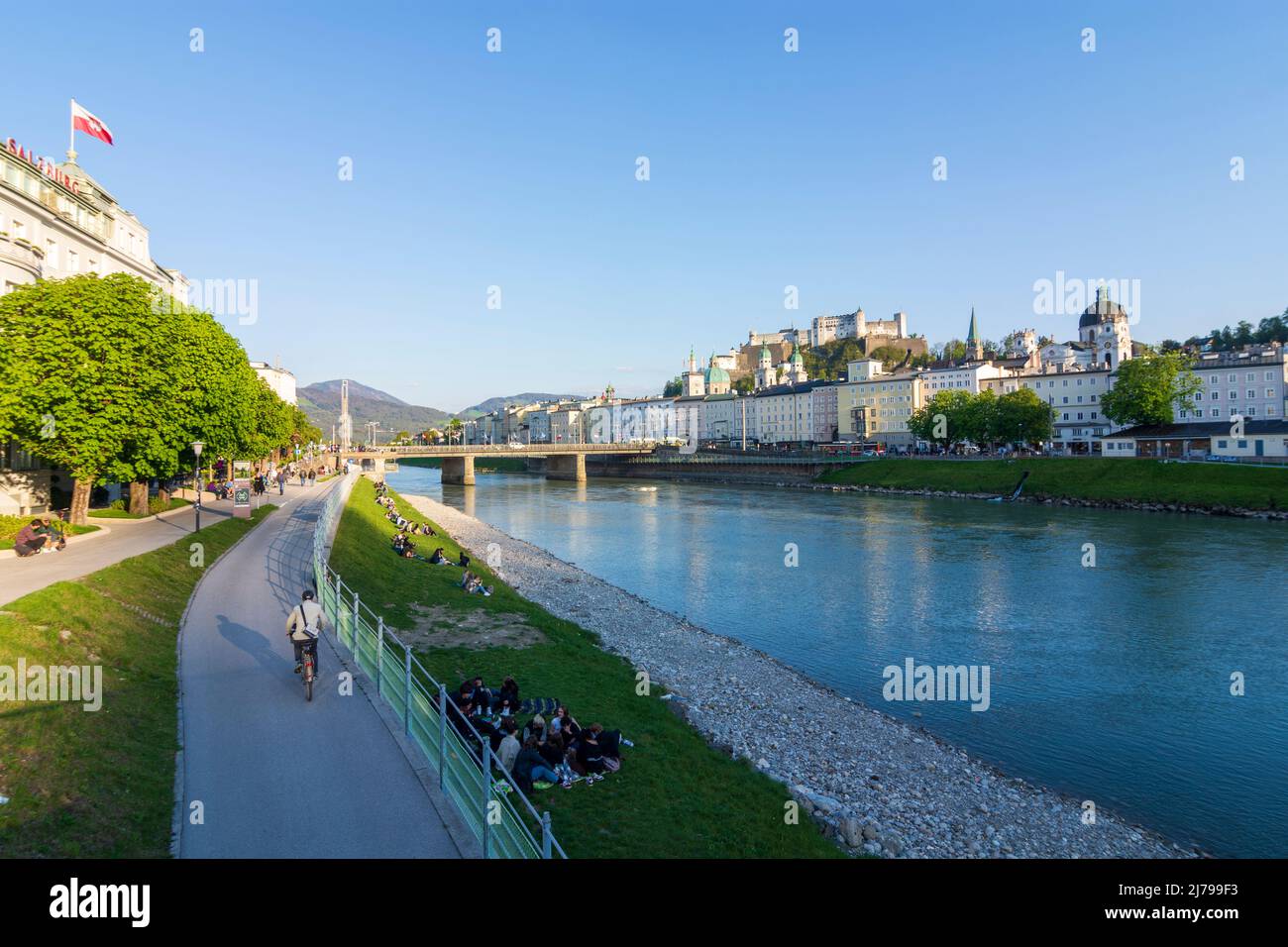 Salzburg: river Salzach, bank Elisabethkai, people sitting on bank of ...