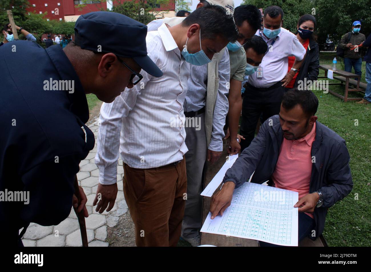 On May 7, 2022 in Kathmandu, Nepal. A man teaches voter to write on a ...