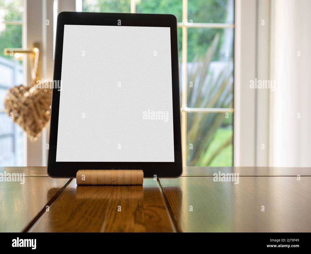 Electronic tablet device with blank screen with stand on an oak table ...
