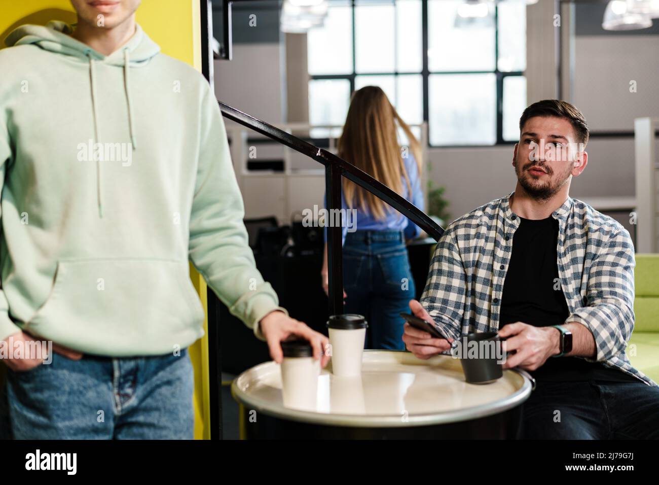Two male colleagues having a talk while coffee break in office Stock ...