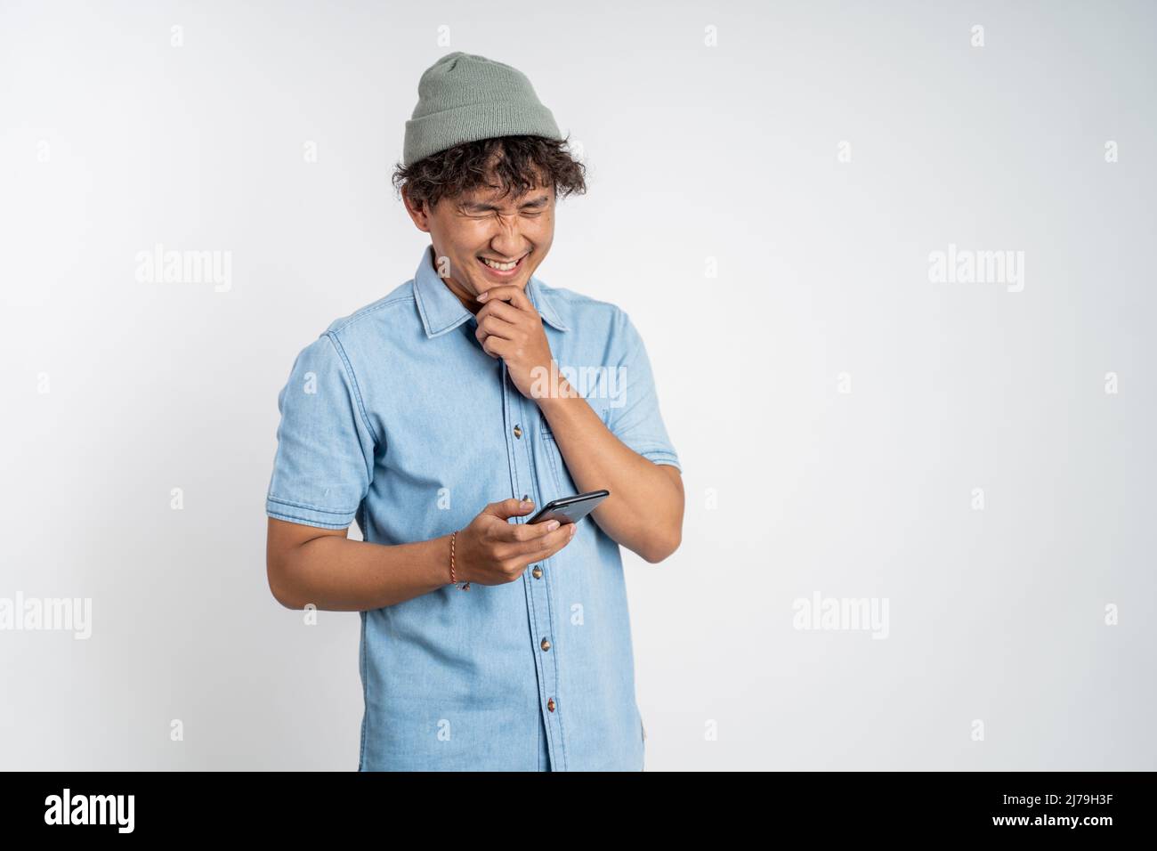 asian young man looking at the screen of a mobile phone Stock Photo - Alamy