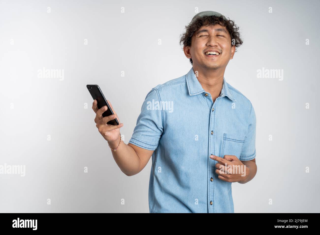confuse young man while looking at his smartphone isolated Stock Photo ...