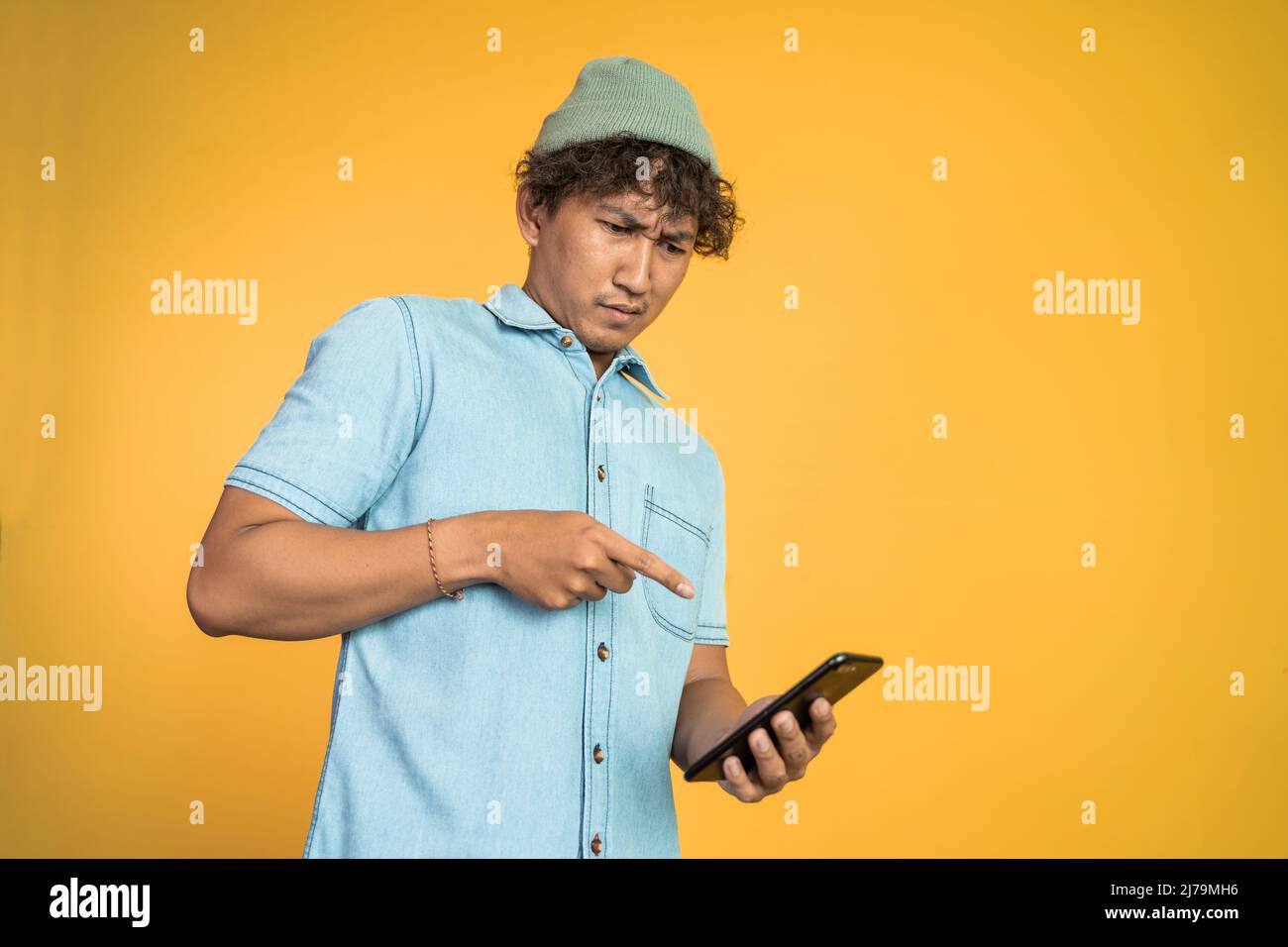 asian young man looking at the screen of a mobile phone Stock Photo - Alamy