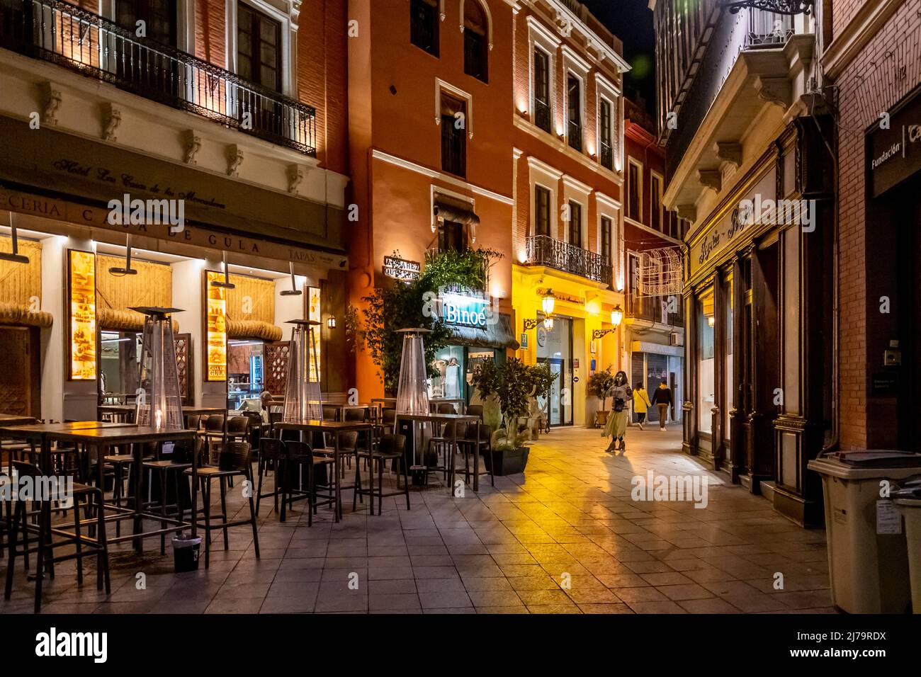 Shops and cafes illuminated at evening in the Barrio Santa Cruz ...