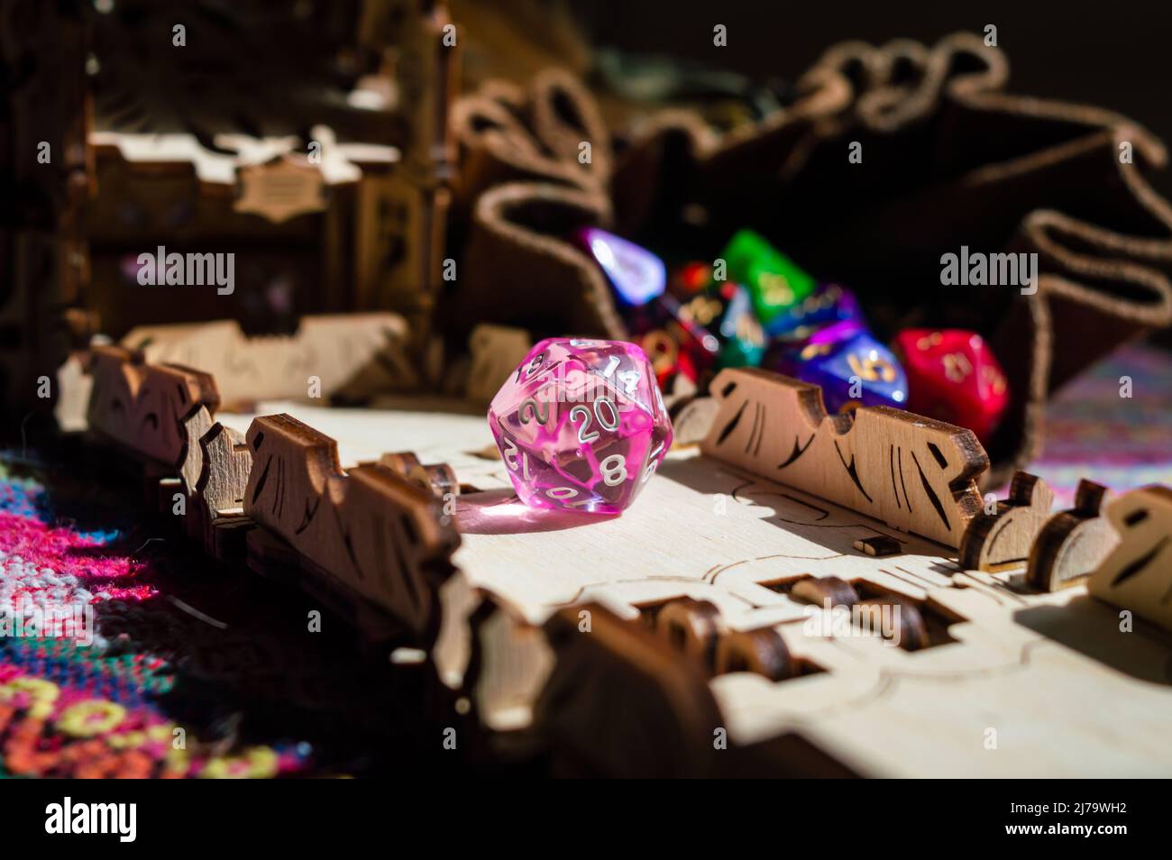 Image of a pink 20-sided role-playing die just rolled out of a dice ...