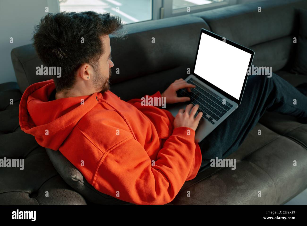 Laptop, young adult has laptop on lap, computer with blank white screen ...