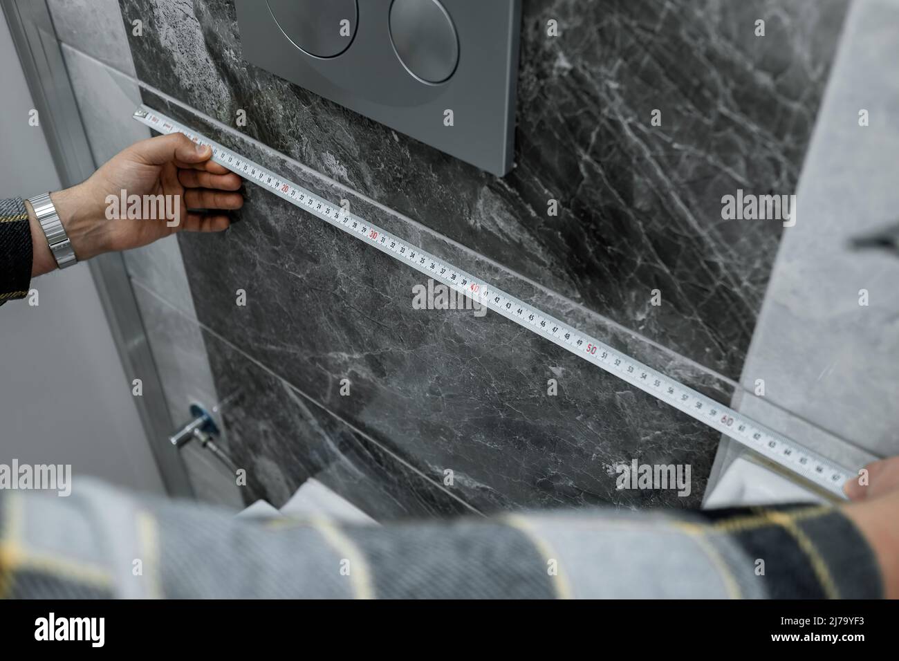 Meter, young marble master takes wall measurements for repair, Marble ...
