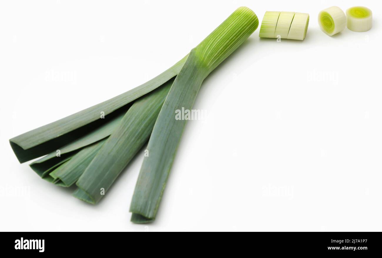 Fresh leek stems and leaves over white background Stock Photo - Alamy