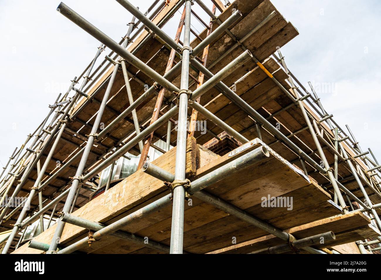 Scaffolding and walkway planks at corner of house during repair work ...