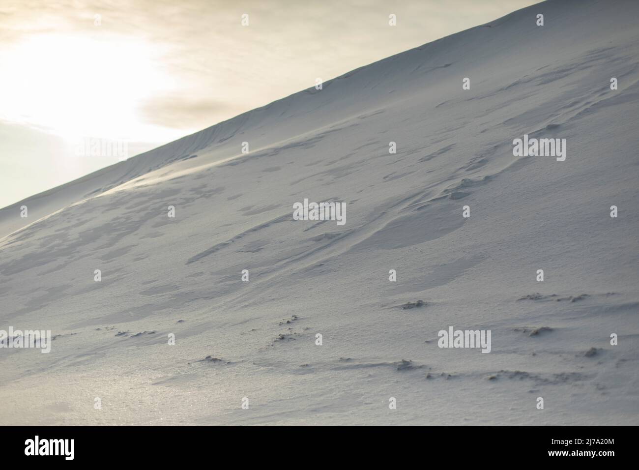 Snowy slope. Snowdrifts in winter. Slide of snow. Weathered surface ...