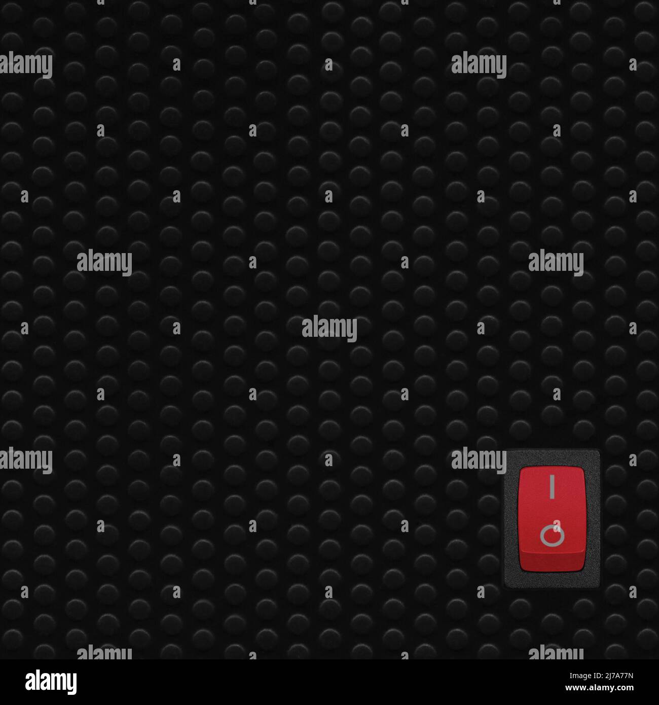 Red rectangle rocker power switch in on position, black abstract dot ...