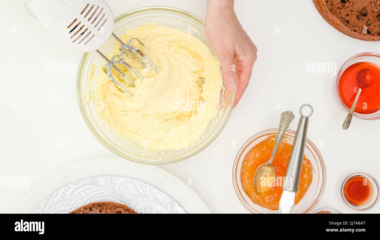 Butter cream, jam, syrup close up in bowls. Woman hands mixing cream ...