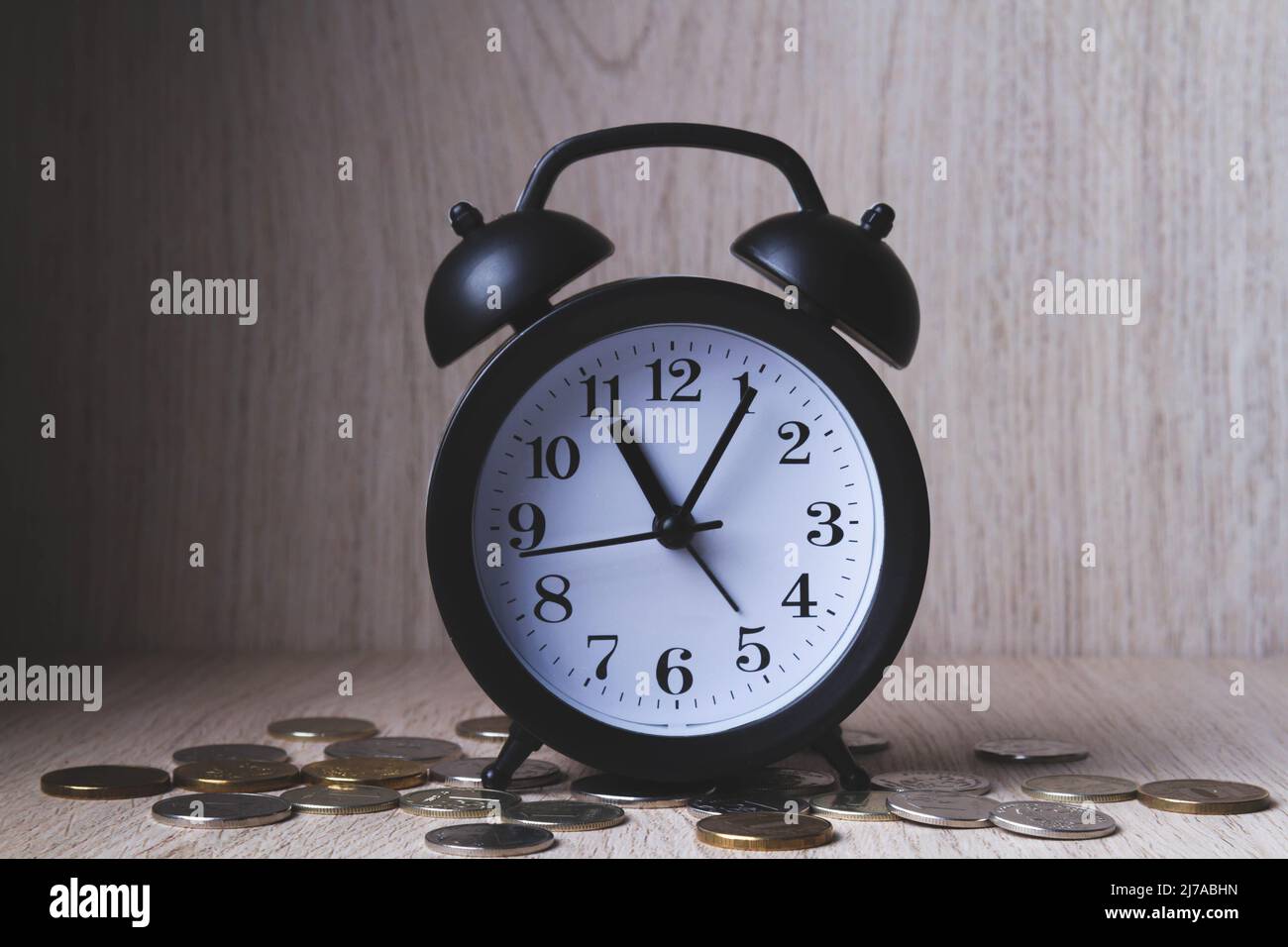 Alarm clock and money. Time is money. Coins on the background of the ...
