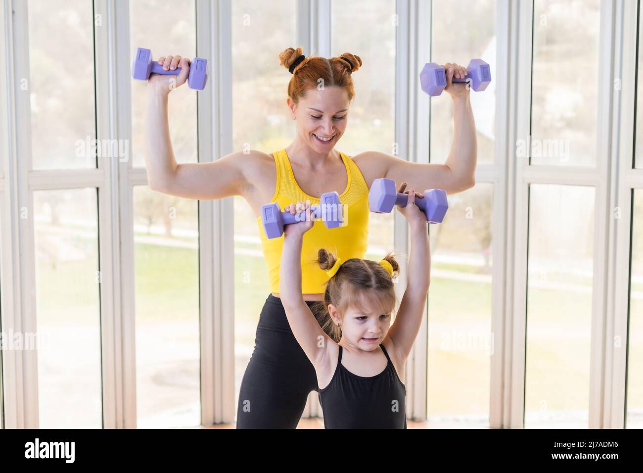 Young Fit Mom And Her Daughter In Matching Clothes Lifting Dumbbell Fitness Motivation Stock