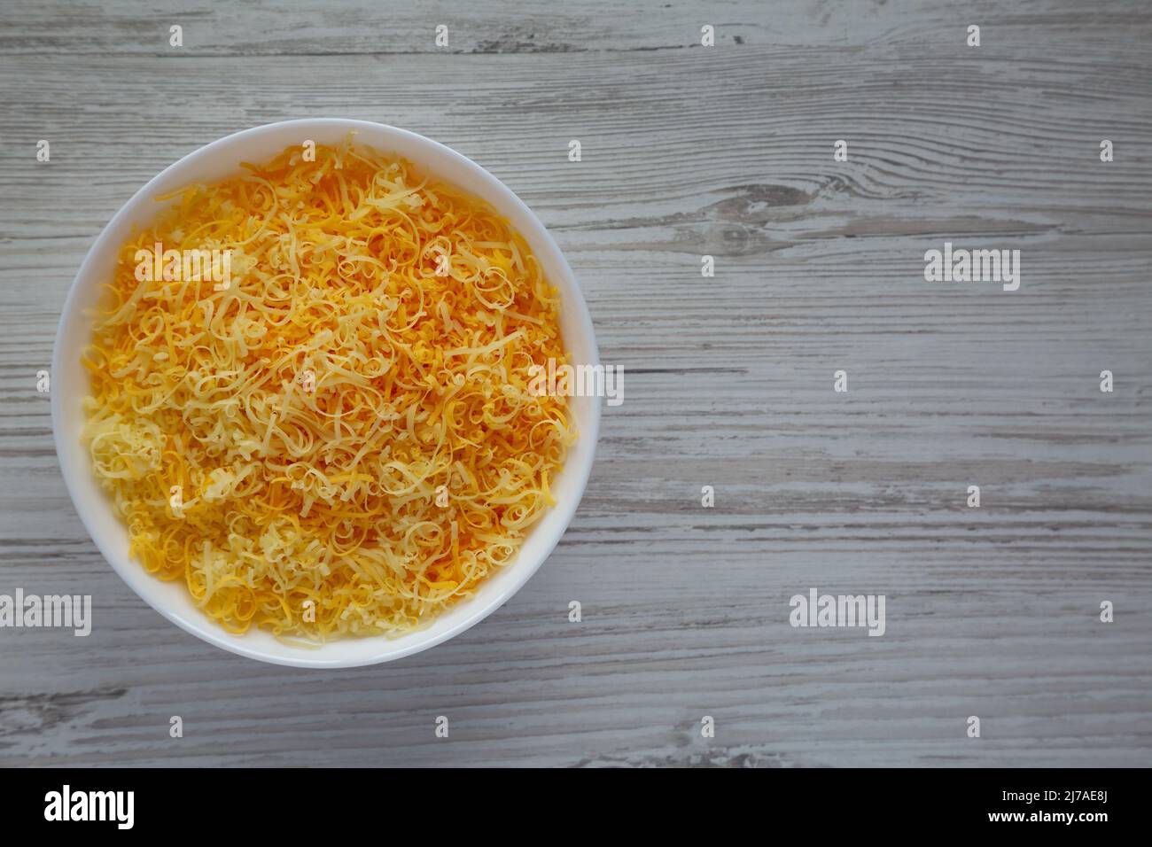 Shredded Mexican Cheese Mix in a White Bowl, top view. Flat lay ...