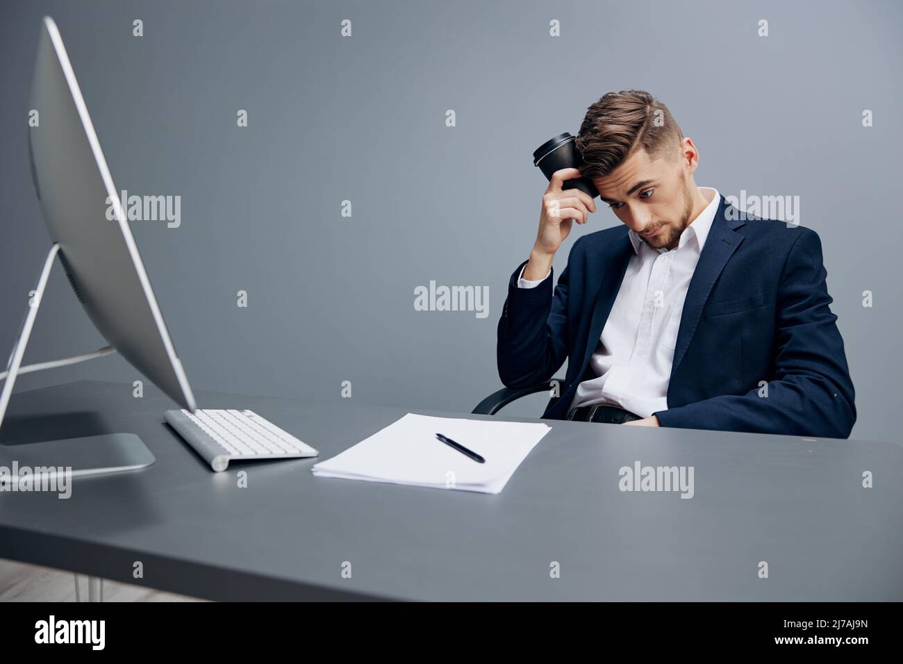 businessmen sitting at a desk in front of a computer Gray background ...