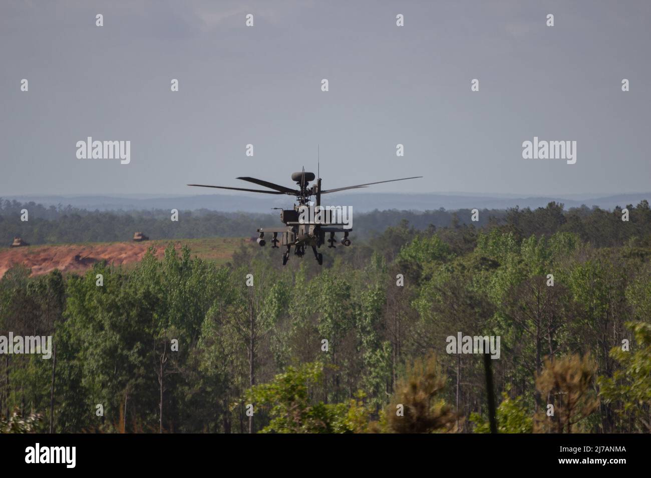 An AH-64 Apache flys over trees during the Operation Thunderstrike ...