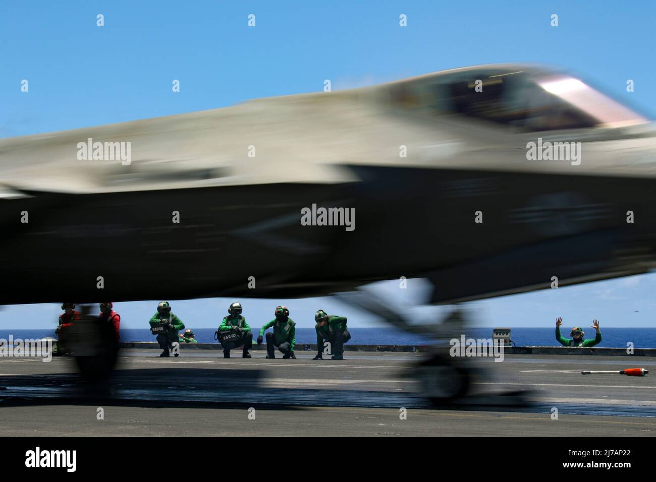 PHILIPPINE SEA (May 6, 2022) Sailors observe an F-35C Lightning II ...