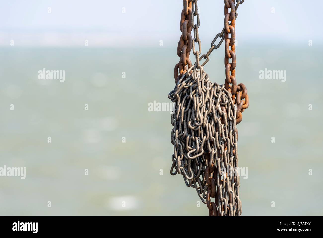 Chain. Bunched chains. Knotted mix of old rusty, and new clean chains ...