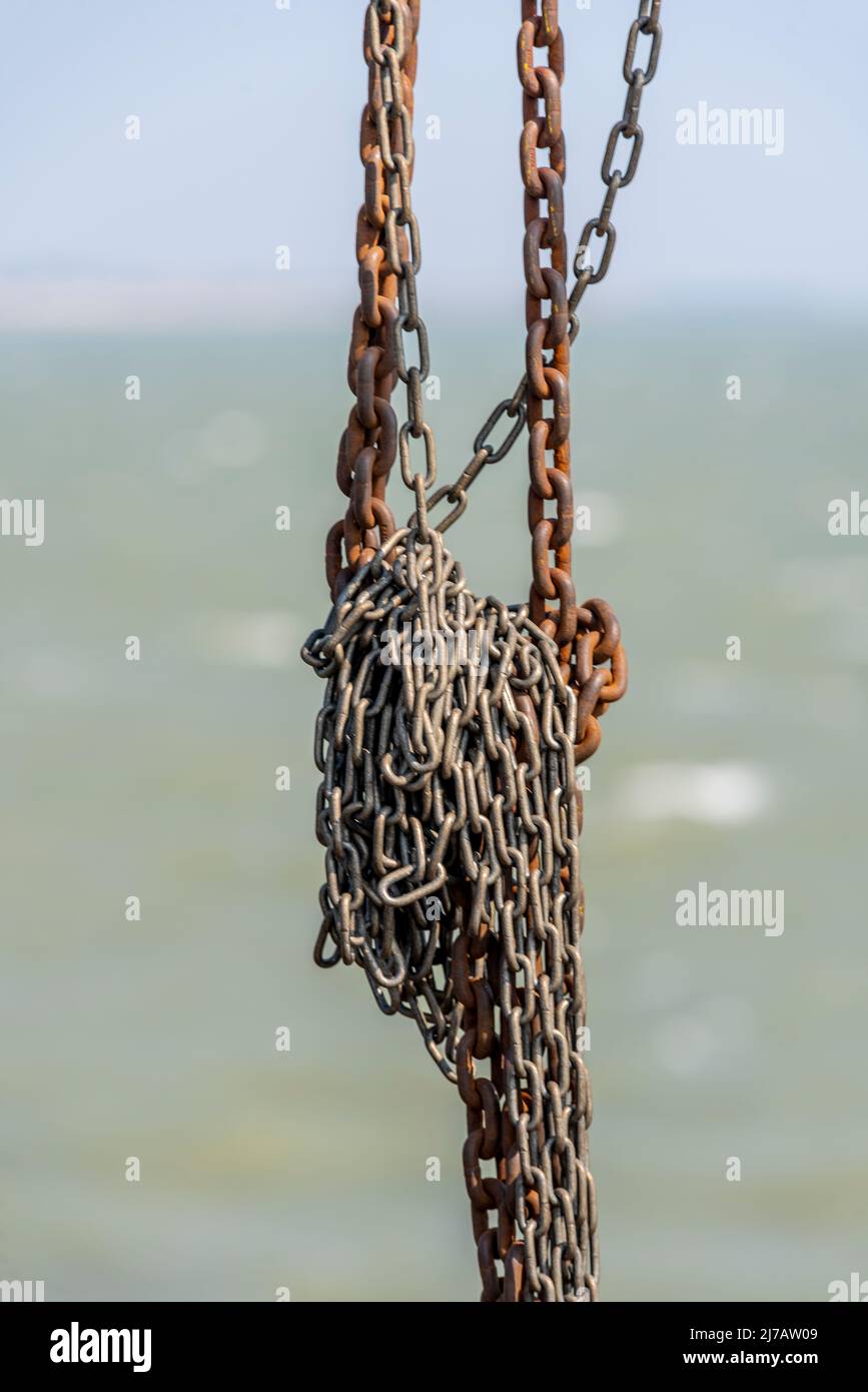 Chain. Bunched chains. Knotted mix of old rusty, and new clean chains ...