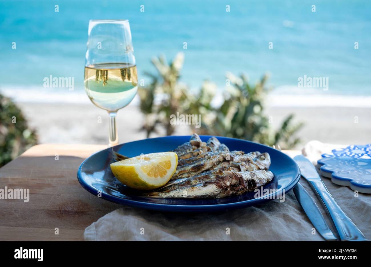 Sardines espeto prepared on skewers and open flame on fireplace with ...