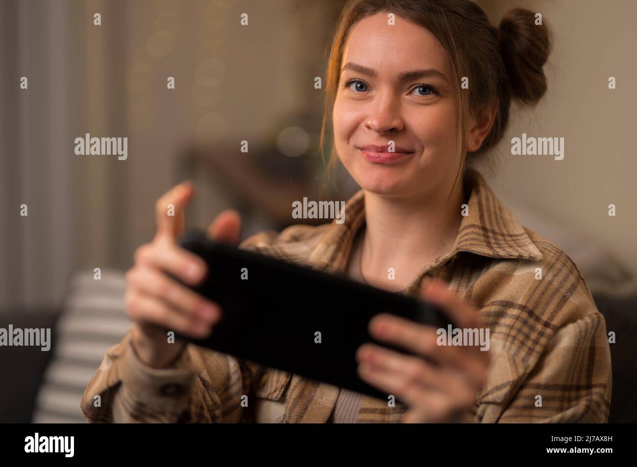 Girl gamer with a portable game console plays video games. Close-up ...