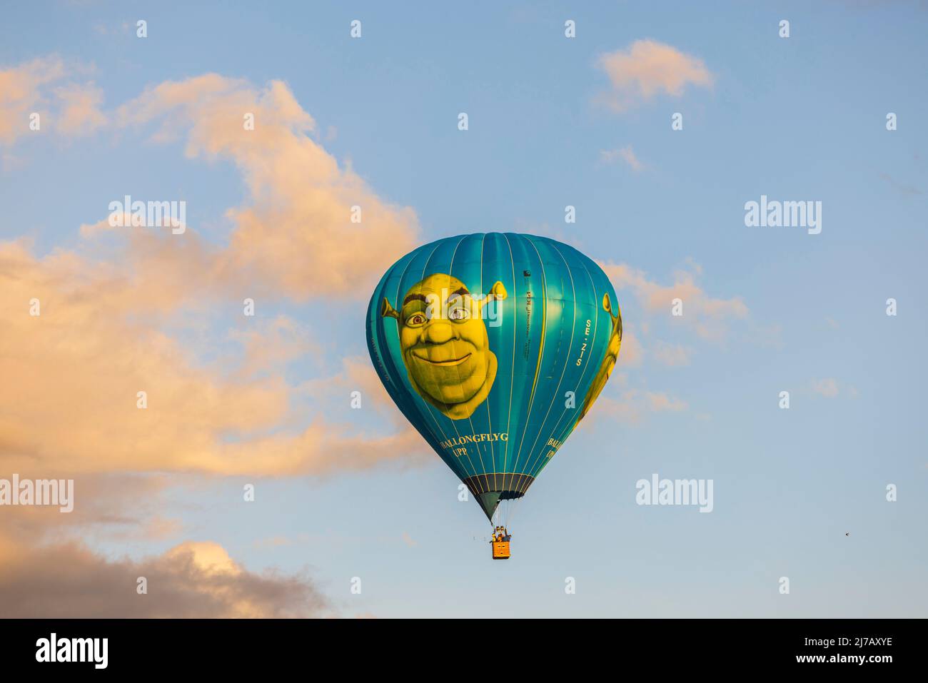 Beautiful view of people flying in hot air balloon far away in blue sky ...