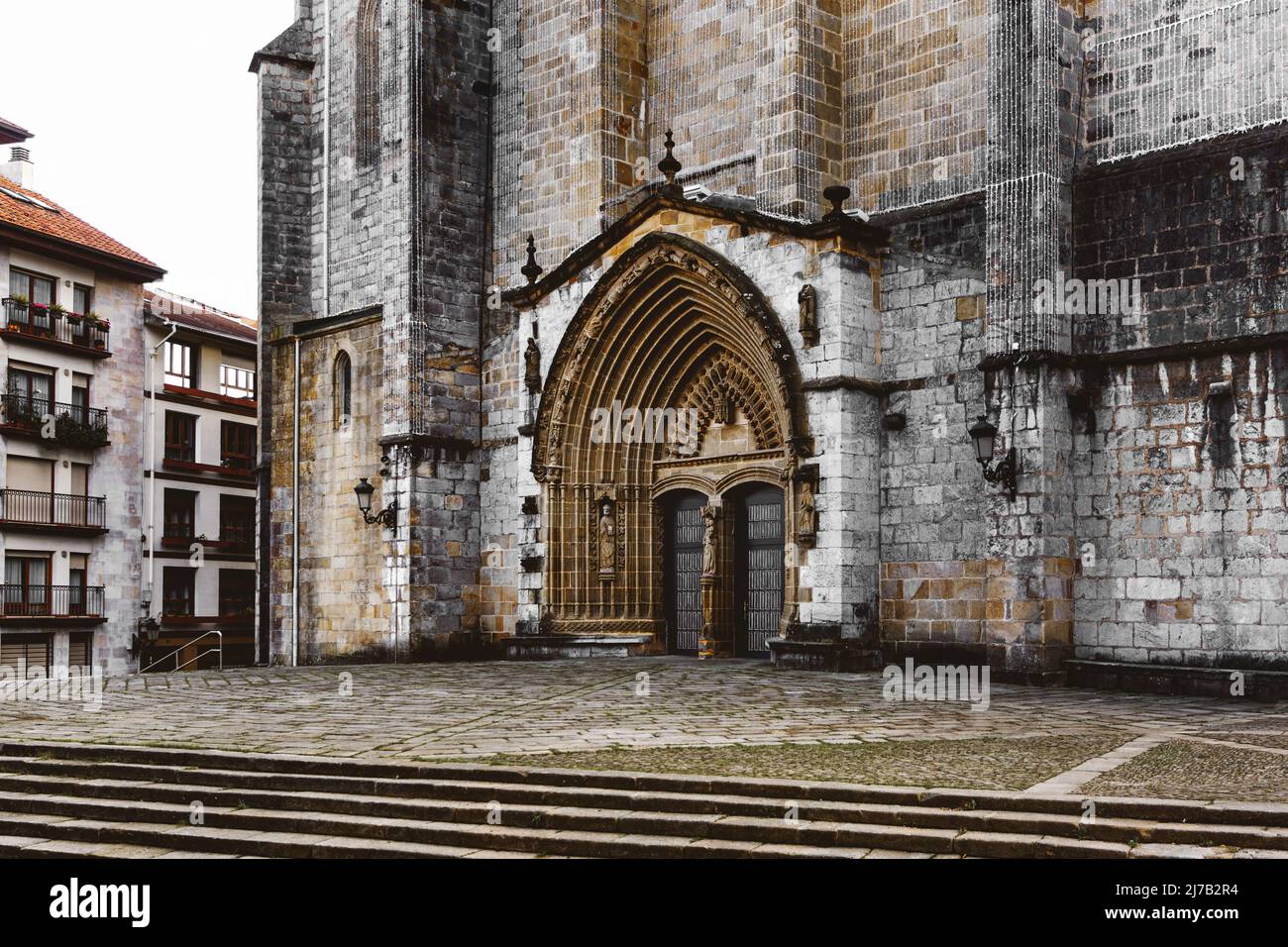 Entrance door and main facade of old stone church in Guernica, Basque ...