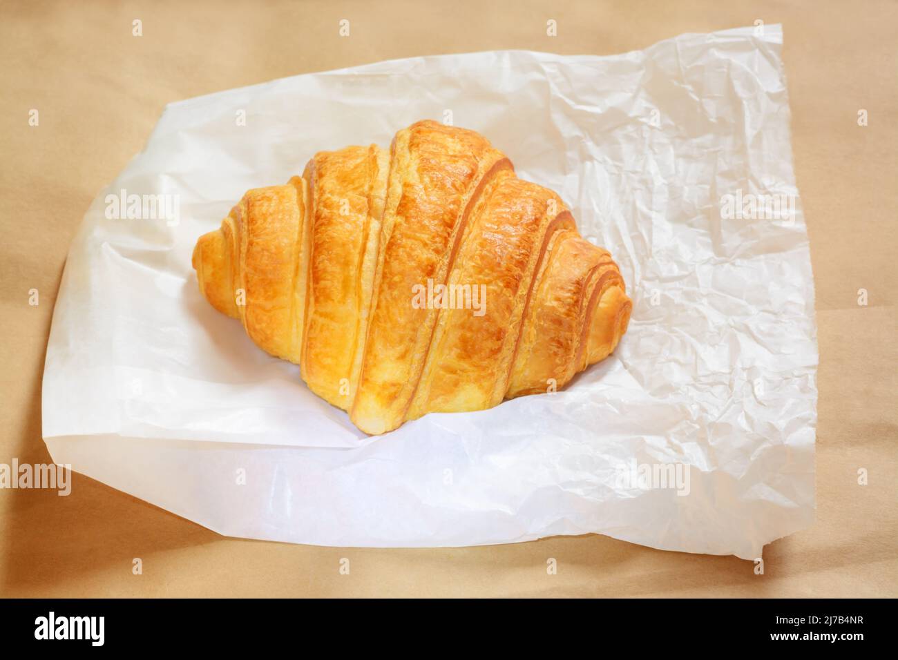 Croissant on the background of white packaging and kraft paper ...