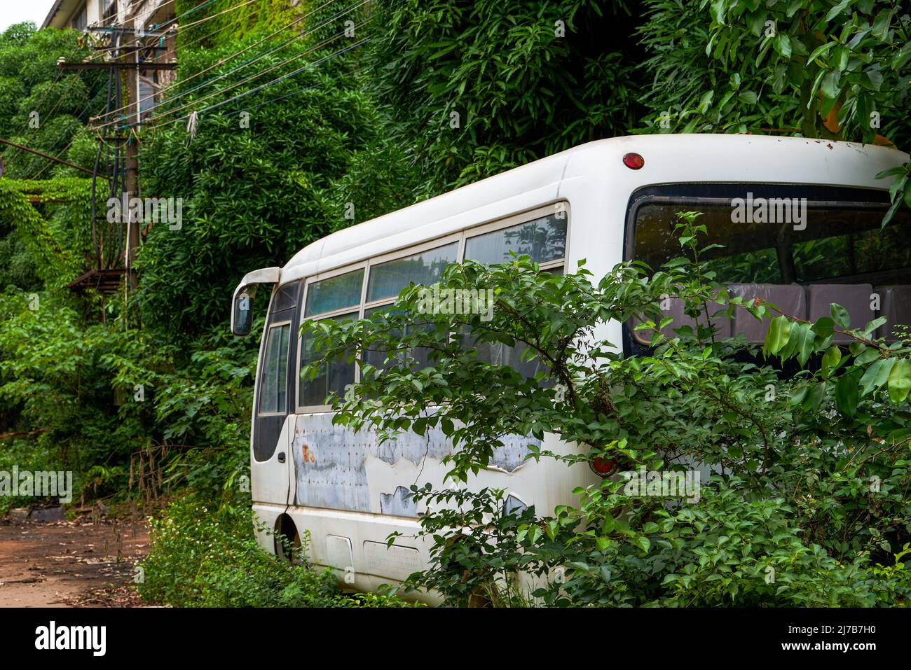 An old minibus passenger car parked in an abandoned industrial park ...