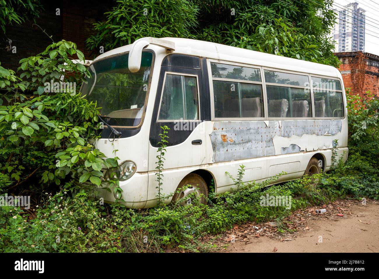 An old minibus passenger car parked in an abandoned industrial park ...