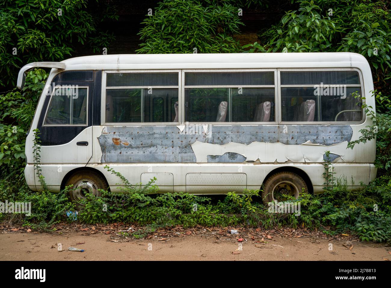 An old minibus passenger car parked in an abandoned industrial park ...