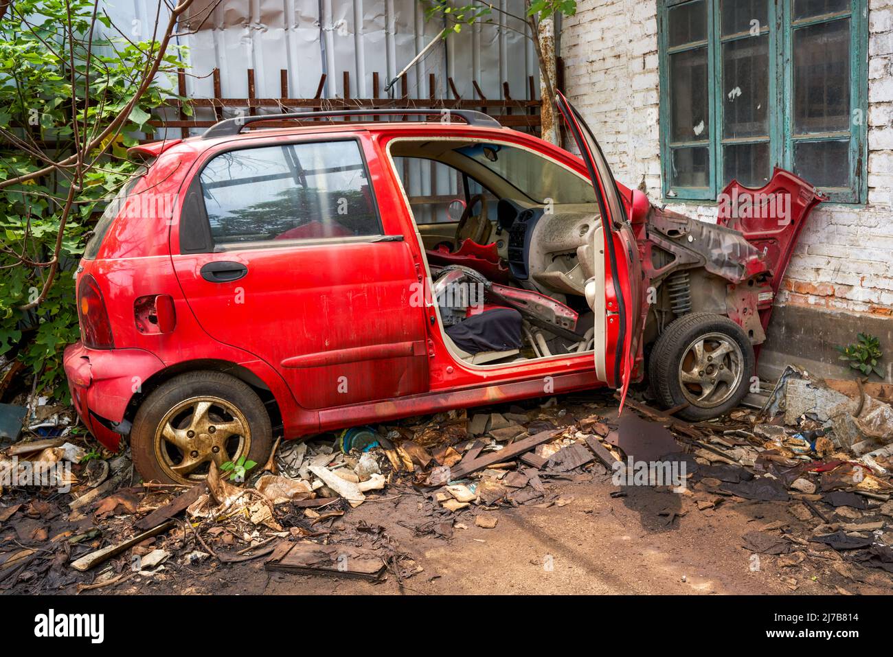 An abandoned and scrapped red hatchback car in the wild Stock Photo - Alamy