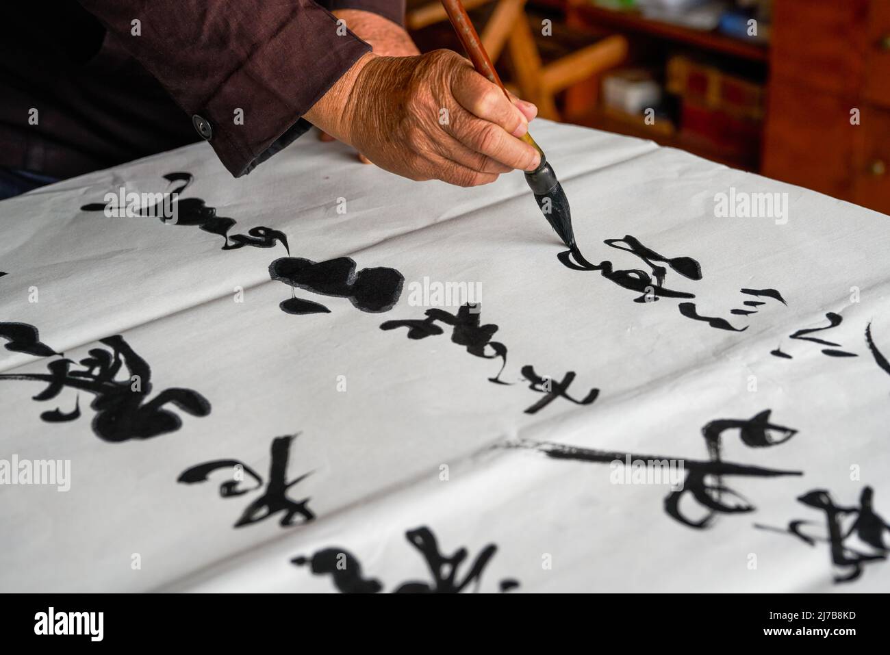 An old calligrapher is writing and creating calligraphy works ...