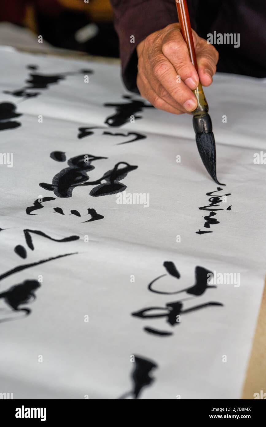 An old calligrapher is writing and creating calligraphy works ...