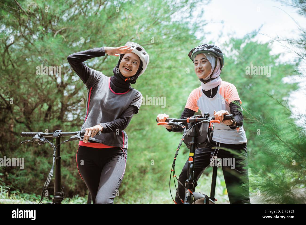 Happiness of two young female cyclists crossing a road Stock Photo - Alamy