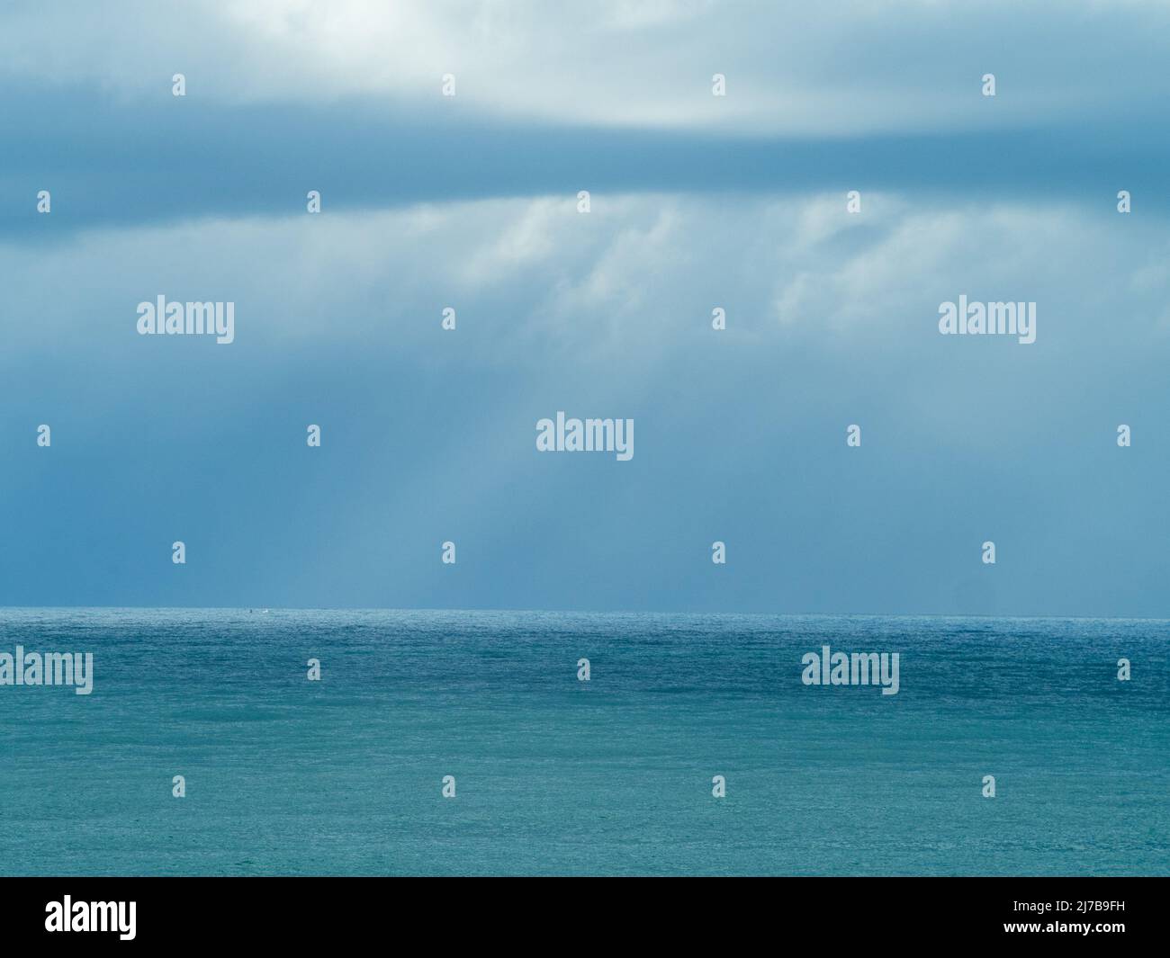 All the blues in sea and storm, layers of blue green and grey, sun ...