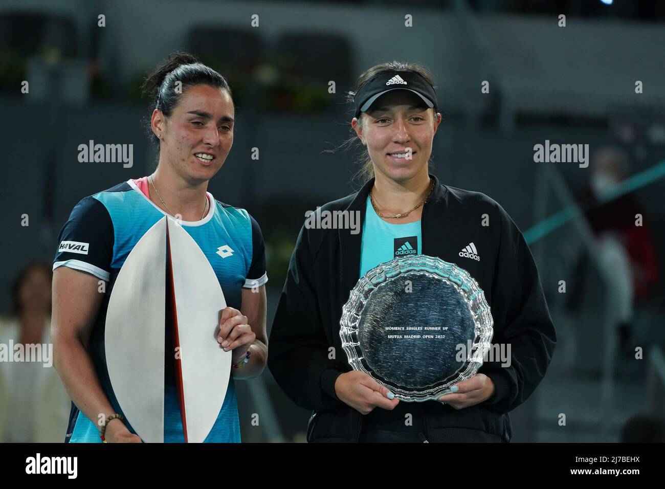 Ons Jabeur (L) of Tunisia celebrates with a trophy and Jessica Pegula ...