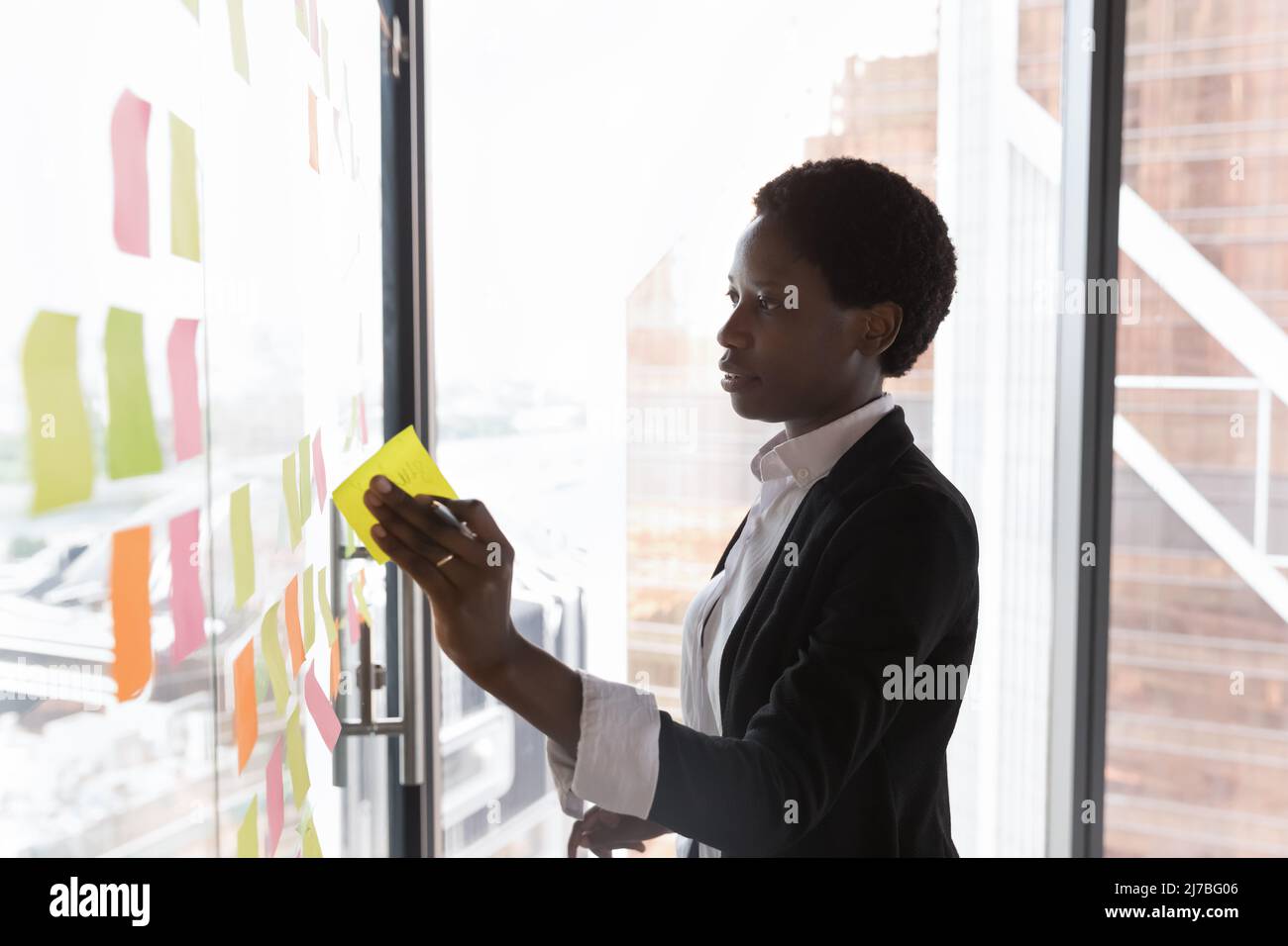 Focused confident Black business leader woman preparing project plan ...