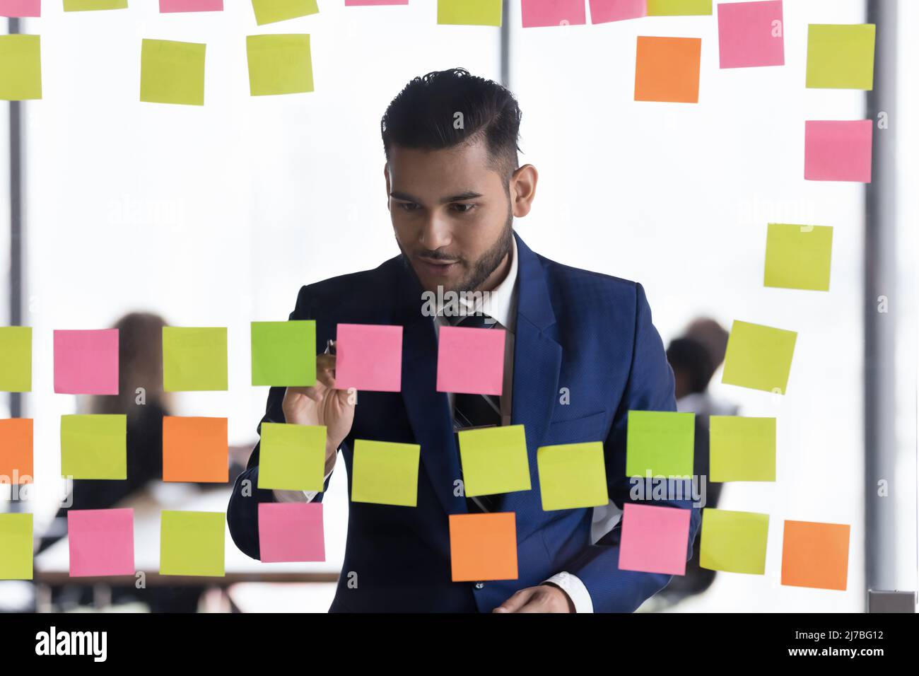 Positive engaged millennial business leader man writing notes Stock ...