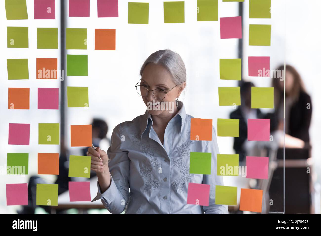 Happy confident mature business leader woman analyzing Kanban board ...
