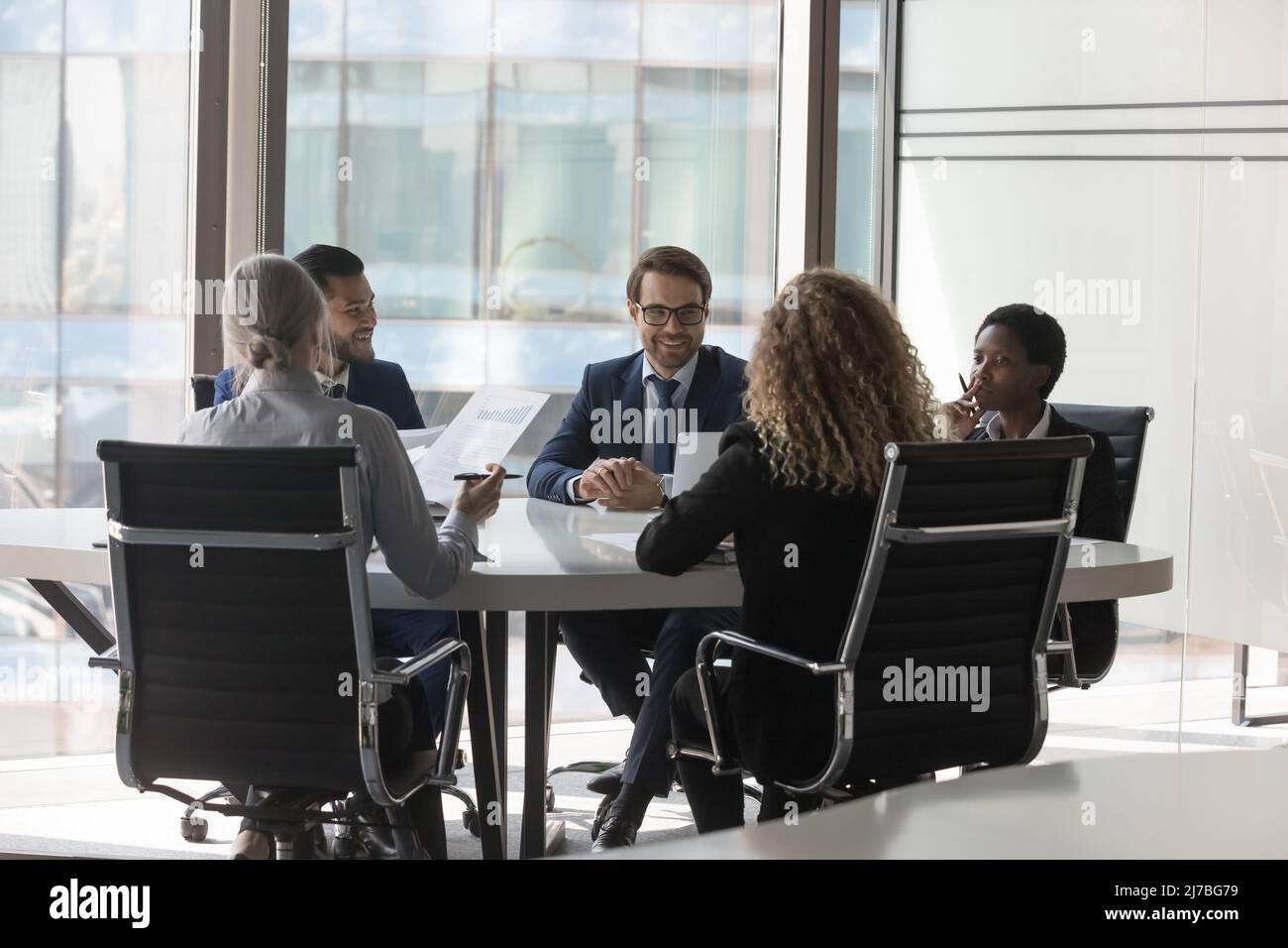 Diverse millennial business group brainstorming, at conference table ...