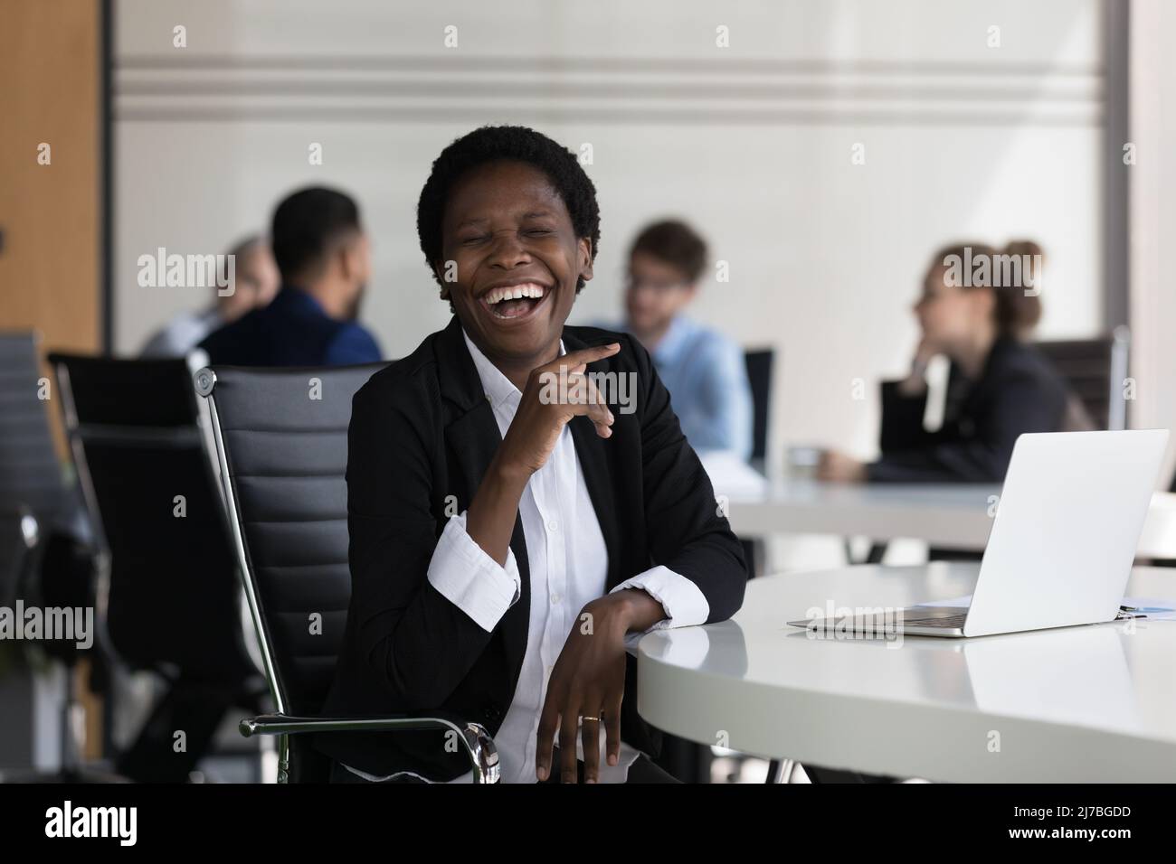 Cheerful excited African business professional woman laughing at ...