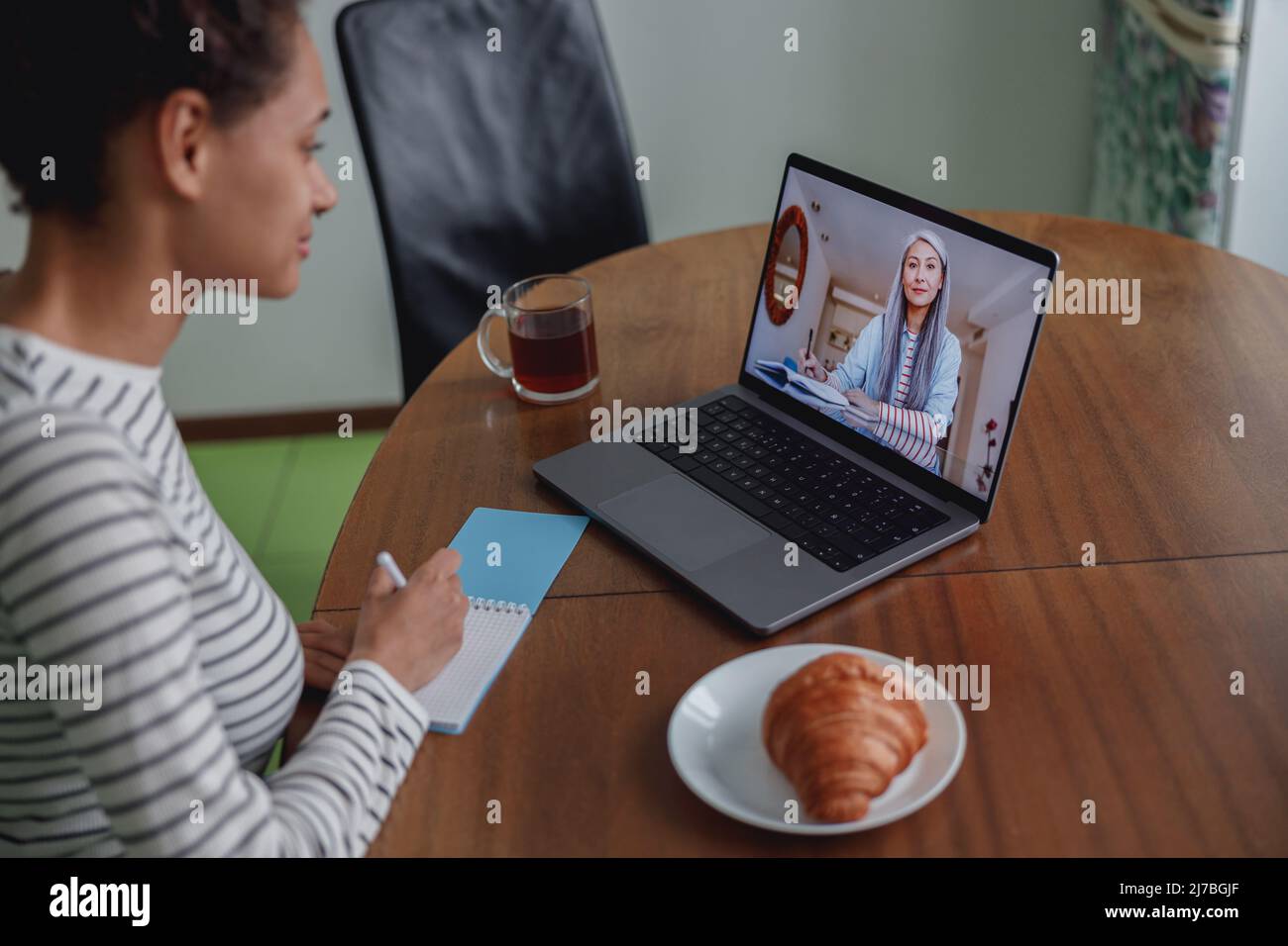 Close up shot of pretty young woman studying having online video lesson ...