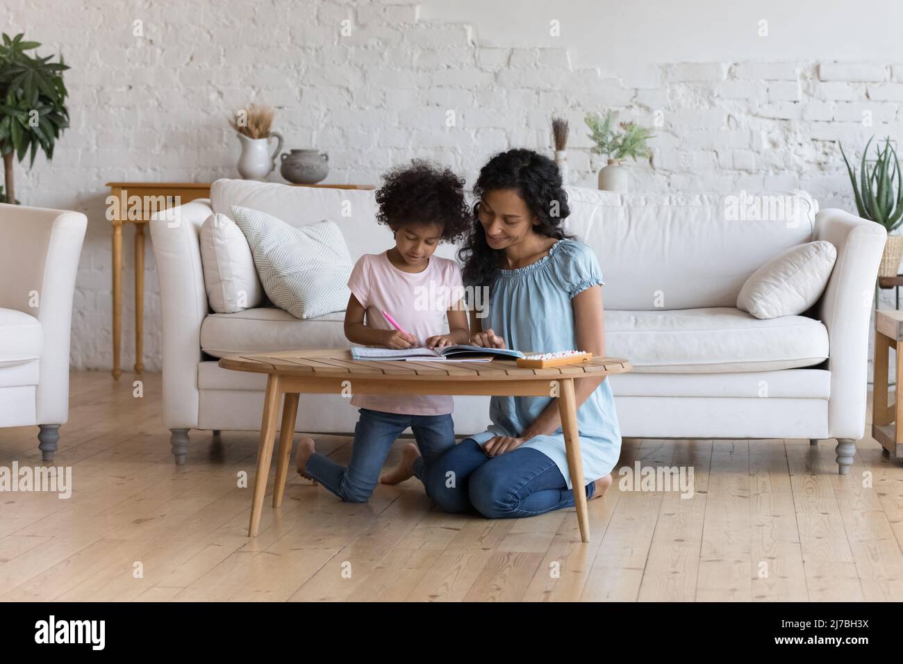 Engaged mom and daughter kid doing primary school homework Stock Photo ...