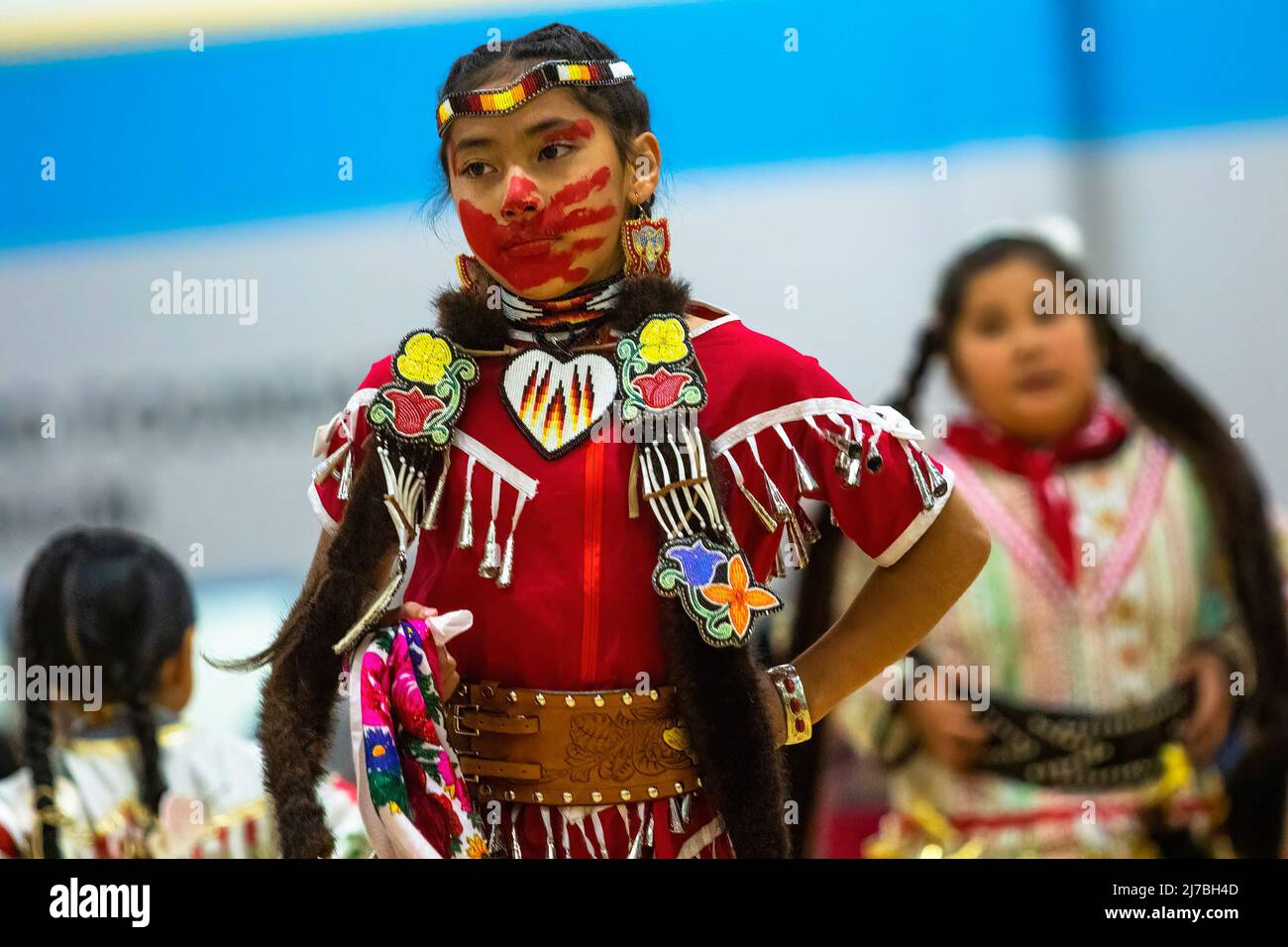 A dancer performs with a red hand print on their face to show ...