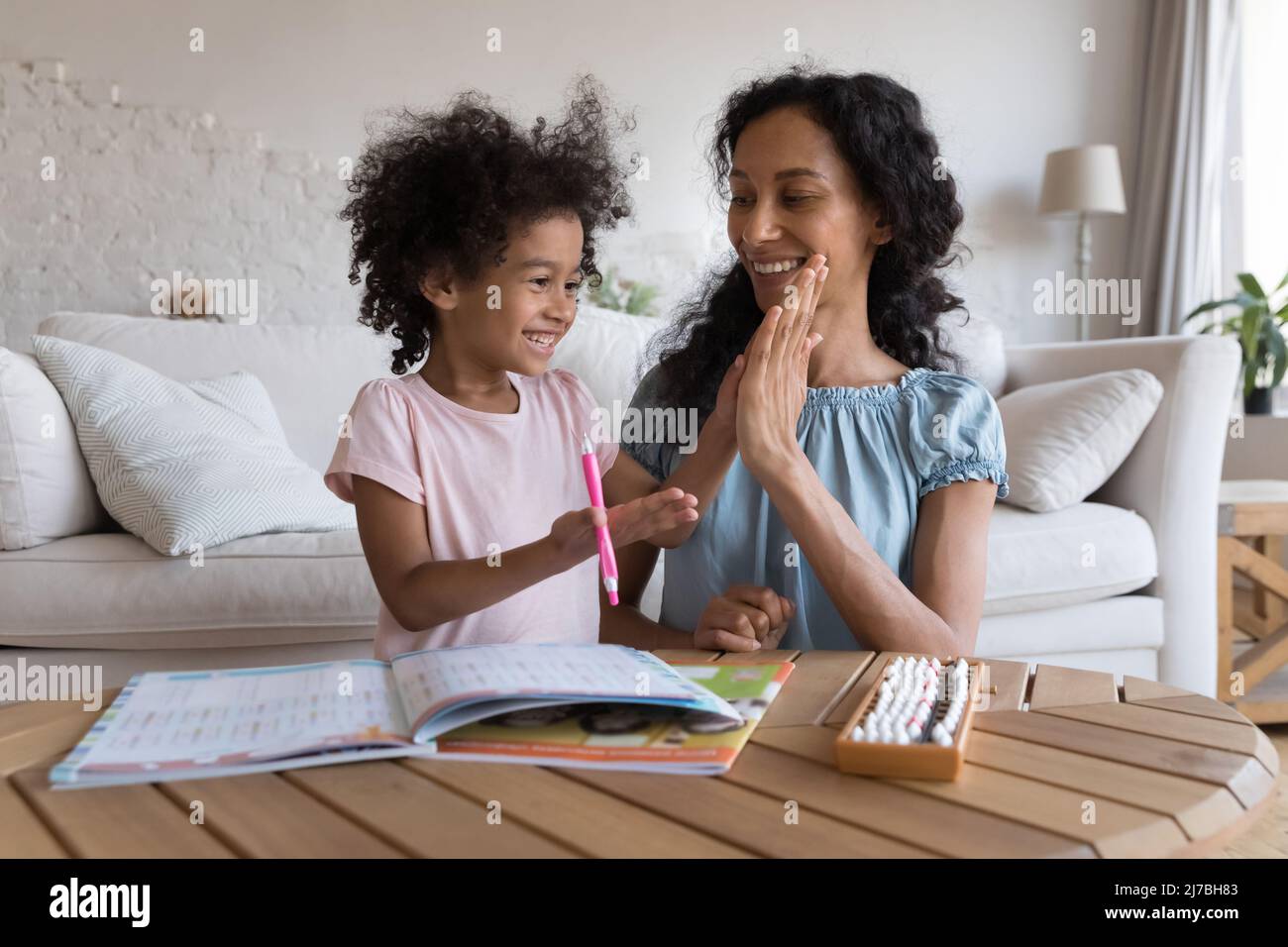 Excited mom and cheerful kid girl clapping high five hands Stock Photo ...
