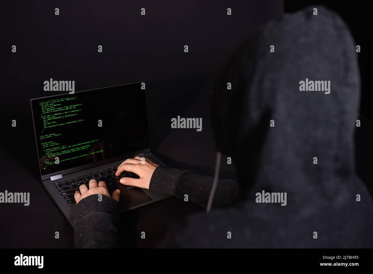 Concept of hacking and malware. Hacker using an abstract laptop with a binary code digital ...