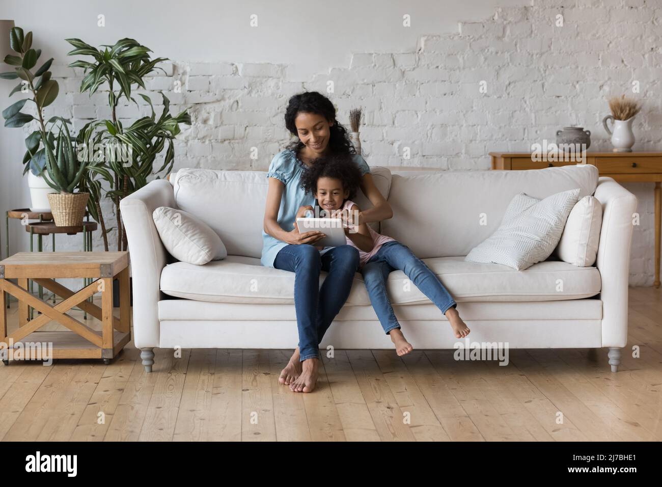 Happy Black mom and cheerful preschool daughter girl reading book Stock ...