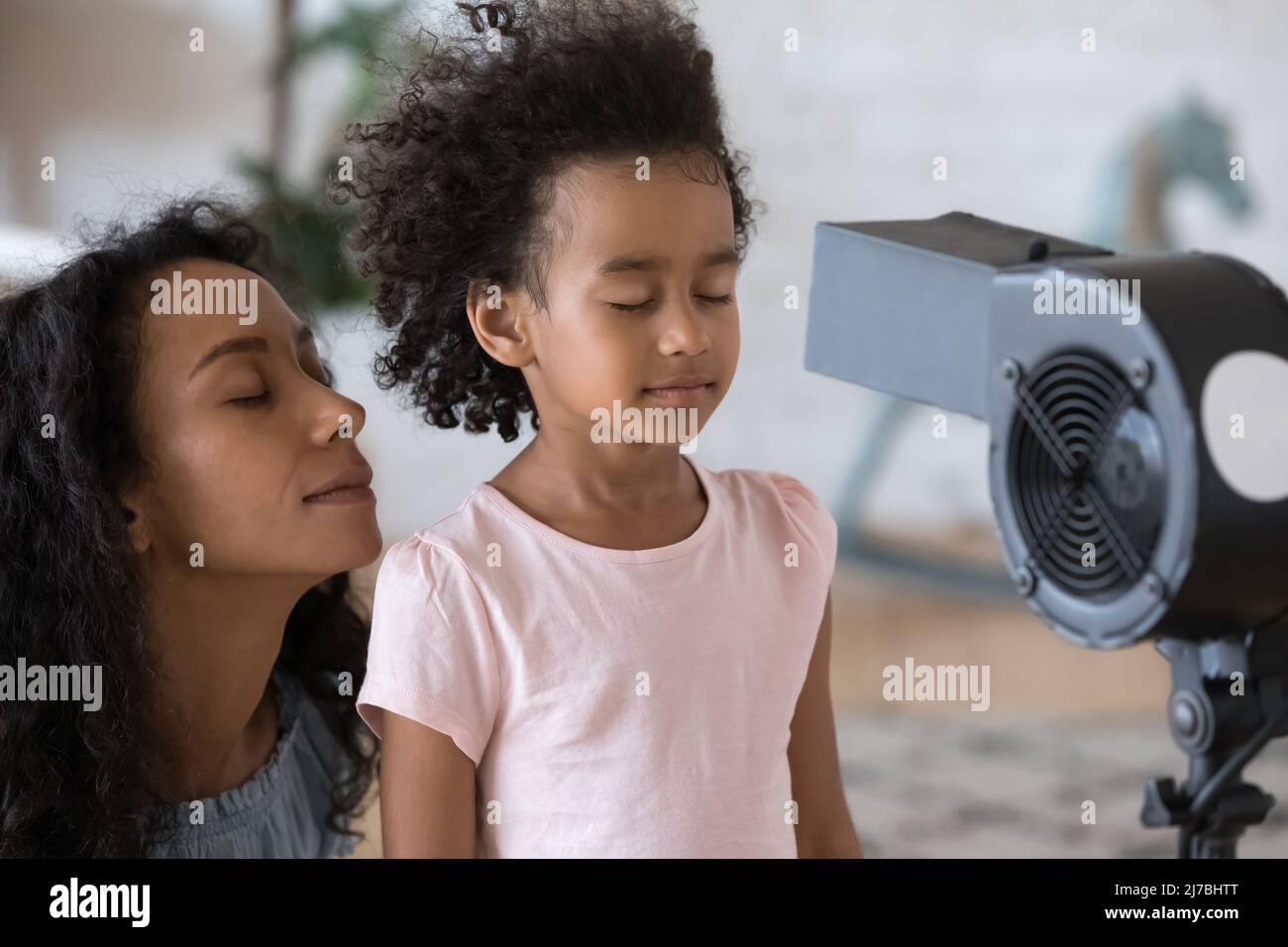Peaceful mom and daughter kid facing cool fresh air flow Stock Photo ...